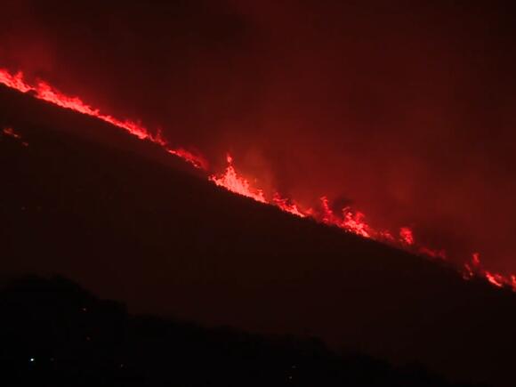 People in evacuation warning zones watch from afar as crews fight ...