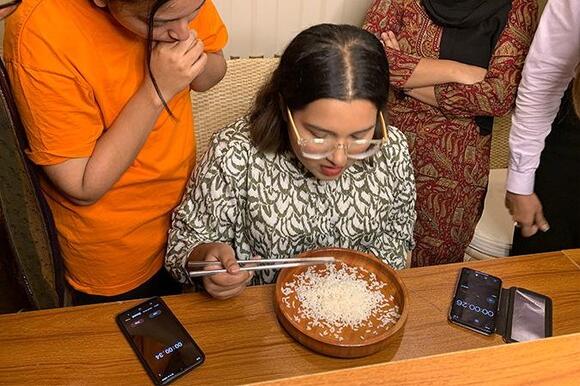 Watch: Woman uses chopsticks to eat one grain of rice at a time - NewsBreak