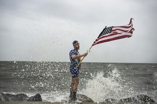 Youtuber Mark Peyton holds a US flag as he poses for his brother Matt ...