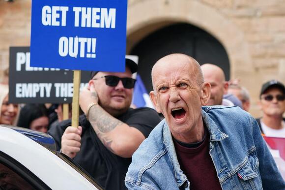 Opposing sides chant and shout outside asylum hotel in Perth - NewsBreak