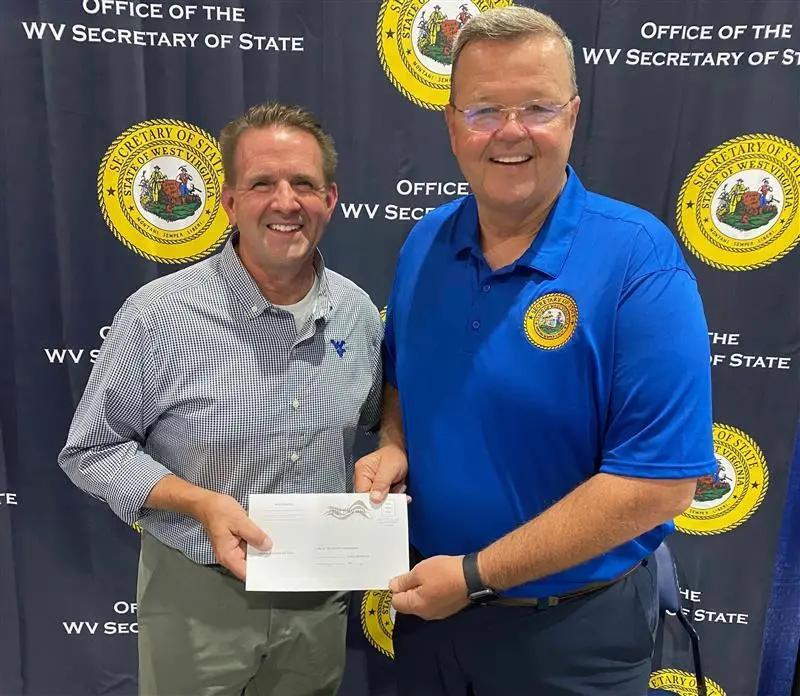 Secretary of State Kris Warner assists new WVU President Michael Benson ...