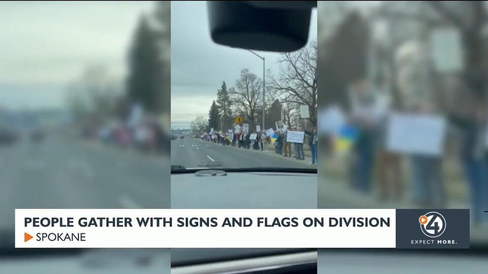 People gather with signs and flags on Division - NewsBreak