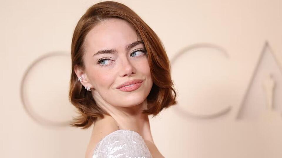 Emma Stone Glows in a Backless Silver Gown at the 2026 Oscars - NewsBreak