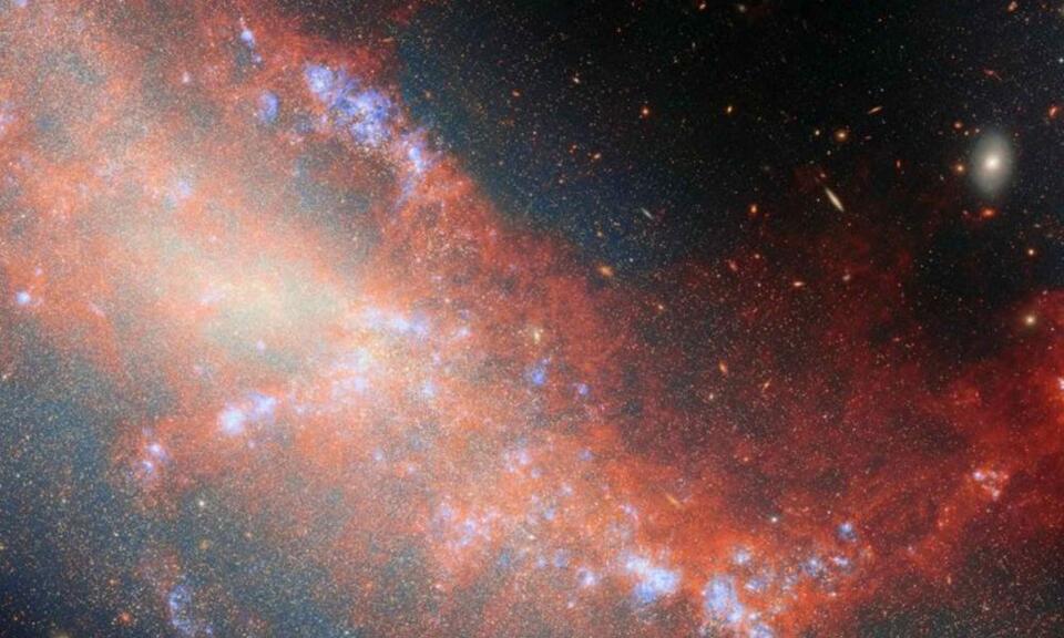 Two dwarf galaxies dance together, connected by a bridge of newborn ...