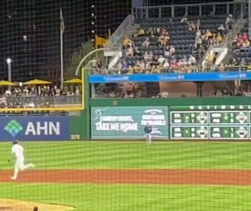 Pirates fan falls onto the warning track during the Pittsburgh/Chicago ...