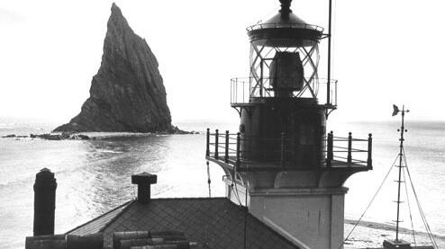 The historic Cape St. Elias Lighthouse on Kayak Island in Alaska has a ...