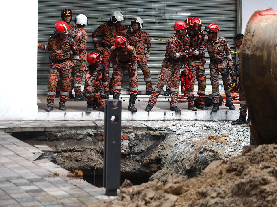 Woman missing after falling into 8m-deep sinkhole after pavement collapses