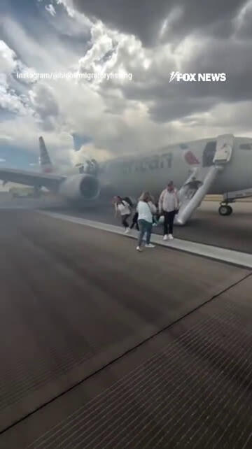 Passengers flee from a burning airplane on the tarmac at Denver ...