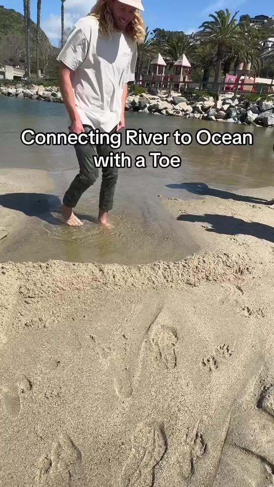 Breaking a sand berm with a toe which connects a river to the ocean ...