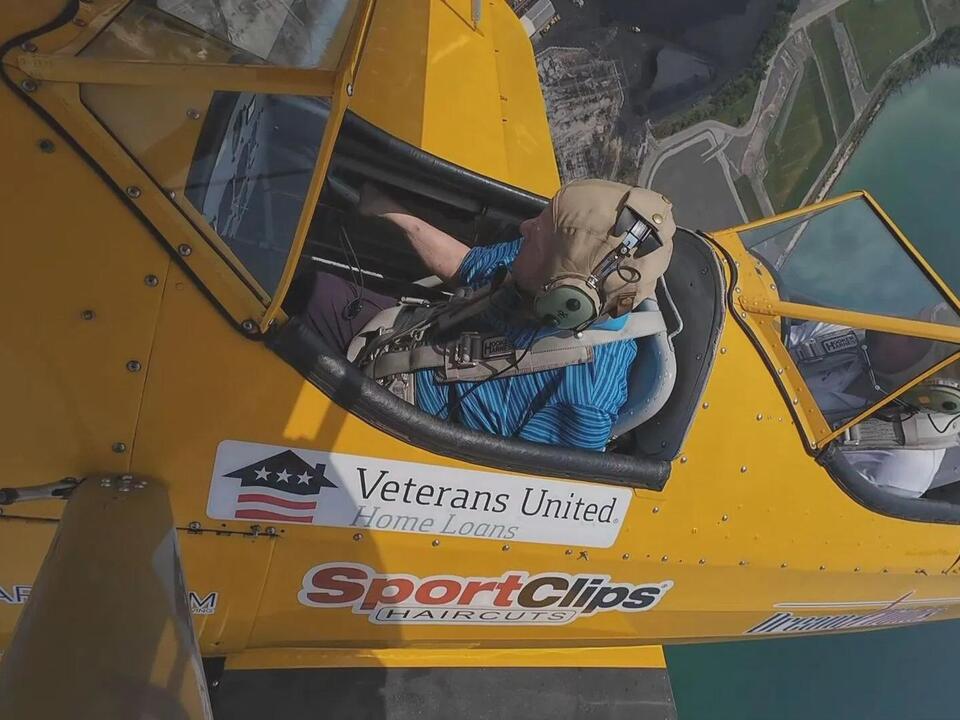 Local senior veterans take flight in an open cockpit biplane