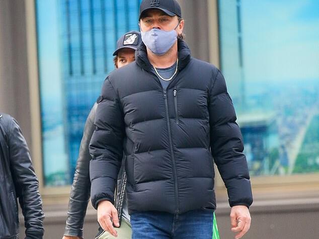 Leonardo DiCaprio covers his face with a cap and protective face mask ...