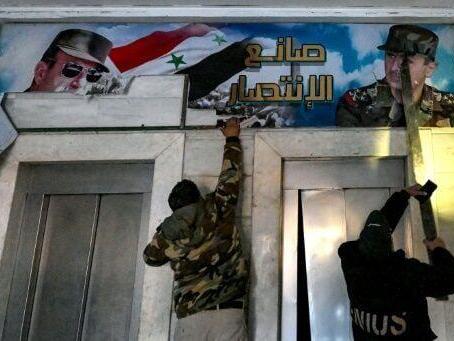 Posters of ousted president Bashar al-Assad and his father Hafez are ...