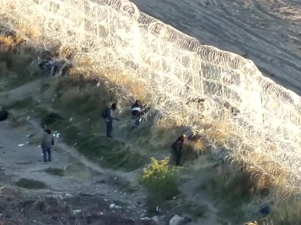Migrants try to cut through razor wire at Texas border, video shows