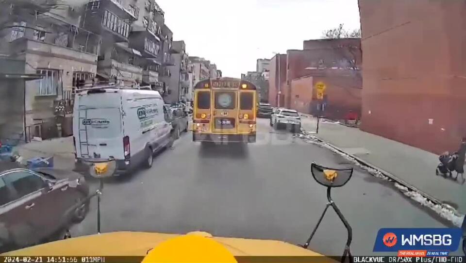 A car is seen passing a school bus on Middleton St with its red ...