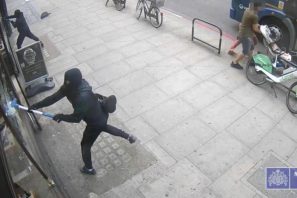 Moment masked raider attacks London store with sledgehammer as gang ...